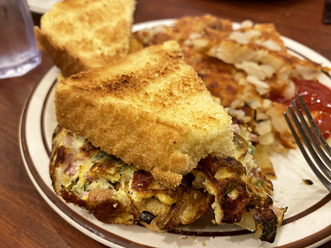 This hearty breakfast creation proves that sometimes the best sandwiches are actually omelets in disguise, nestled between golden toast.