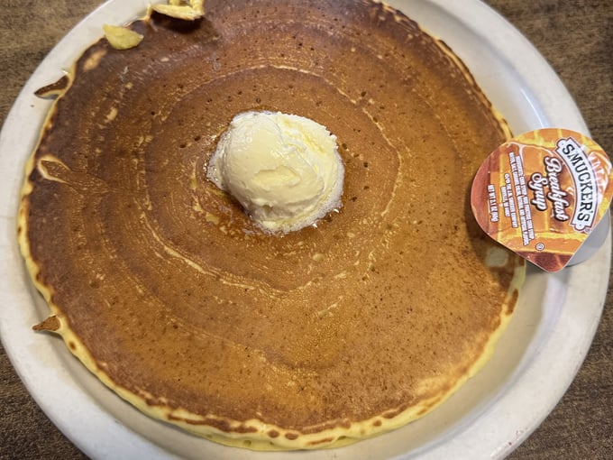 Pancakes so perfect they deserve their own zip code, topped with a scoop of butter slowly melting into breakfast nirvana.