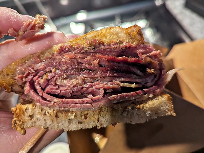This isn't just a sandwich; it's a skyscraper of hand-sliced pastrami that makes you wonder if your jaw will unhinge like a snake's.