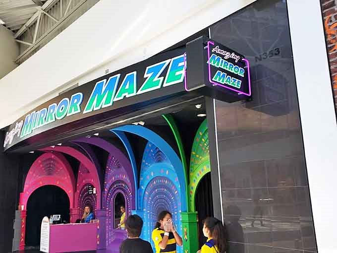 The illuminated signage serves as a beacon for the disorientation-curious, promising an adventure in perception just steps away.