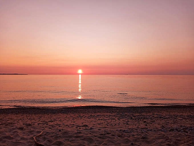 Sunset paints the horizon in gentle pastels, mirroring the soft hues of the beach below in a perfect color harmony.