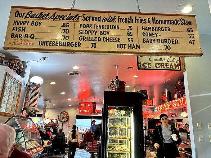 The vintage menu board hanging above the counter is a nostalgic treasure, showcasing classic American favorites at prices that sadly aren't honored anymore.