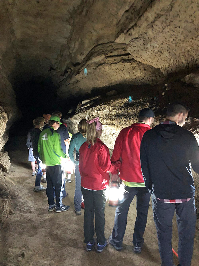 Visitors gather to marvel at the cave's wonders, their faces lit by carefully placed lighting that highlights the natural beauty.