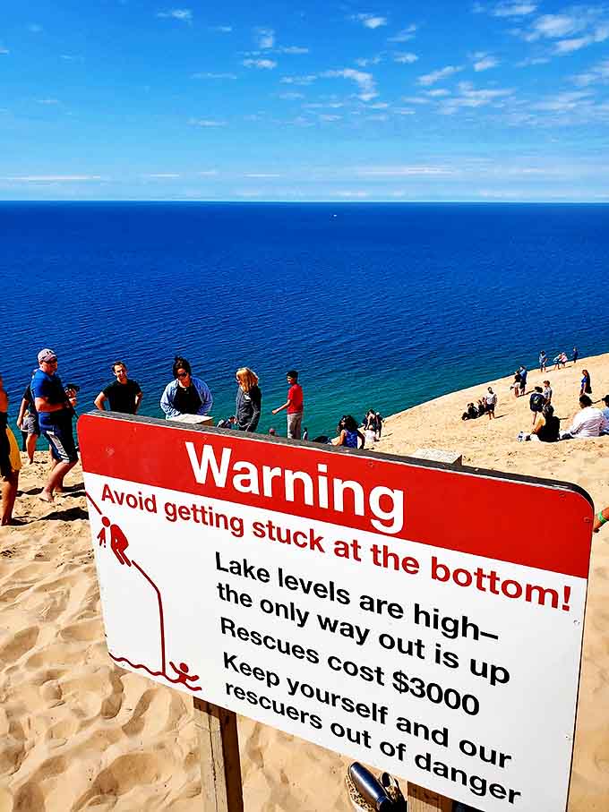 A warning sign adds perspective to the massive scale of Sleeping Bear Dunes, where the climb down (and back up!) is not for the faint of heart.