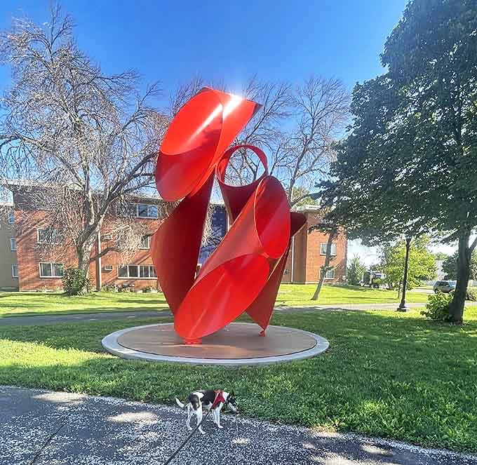 The vibrant red sculpture twists toward the sky like frozen flames, bringing a burst of color to the landscape even on gray days.