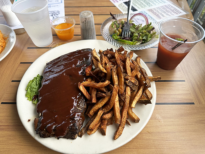 Fall-off-the-bone BBQ ribs slathered in house sauce with golden fries &ndash; comfort food elevated to an art form by the lake.
