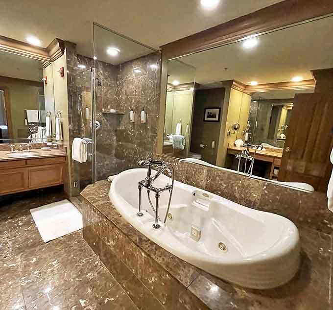 Marble luxury surrounds a deep soaking tub that practically whispers, "Cancel your plans and grab that paperback you've been meaning to finish."