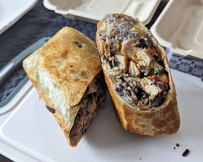 A masterclass in architectural eating &ndash; this perfectly wrapped package delivers rice, beans, and seasoned chicken in every balanced bite.