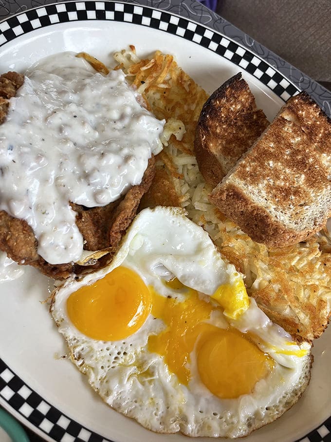 Country Fried Steak Breakfast: Morning glory on a plate&mdash;crispy breaded steak swimming in peppery gravy alongside sunny eggs and golden hashbrowns.
