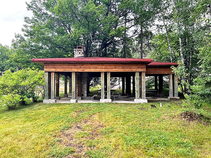 The open-air pavilion offers welcome shade and gathering space, its rustic timber construction echoing the natural materials that define this unique artistic environment.