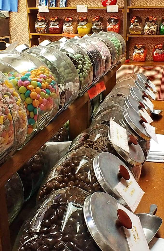 Glass jars tilted at perfect angles display bulk candies, making selection both easy and dangerously tempting.