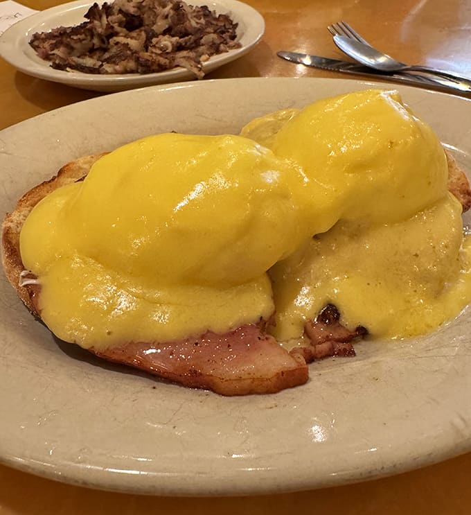 Eggs Benedict done right – perfectly poached eggs nestled on Canadian bacon, draped in hollandaise that's rich enough to make a Frenchman weep.