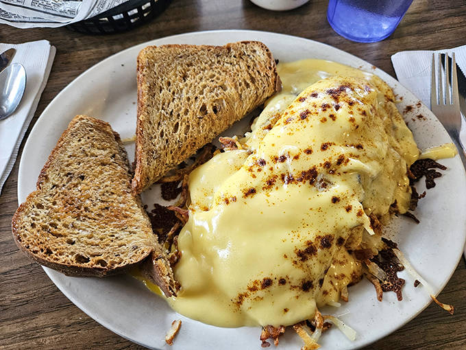 Eggs Benedict done right &ndash; hollandaise sauce cascading down like a yellow waterfall of buttery goodness over perfectly poached eggs.