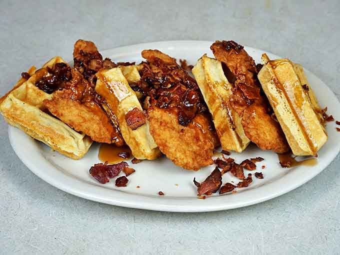 Chicken and waffles playing the ultimate sweet-savory tango, with crispy poultry dancing across golden waffle squares drizzled with maple goodness.