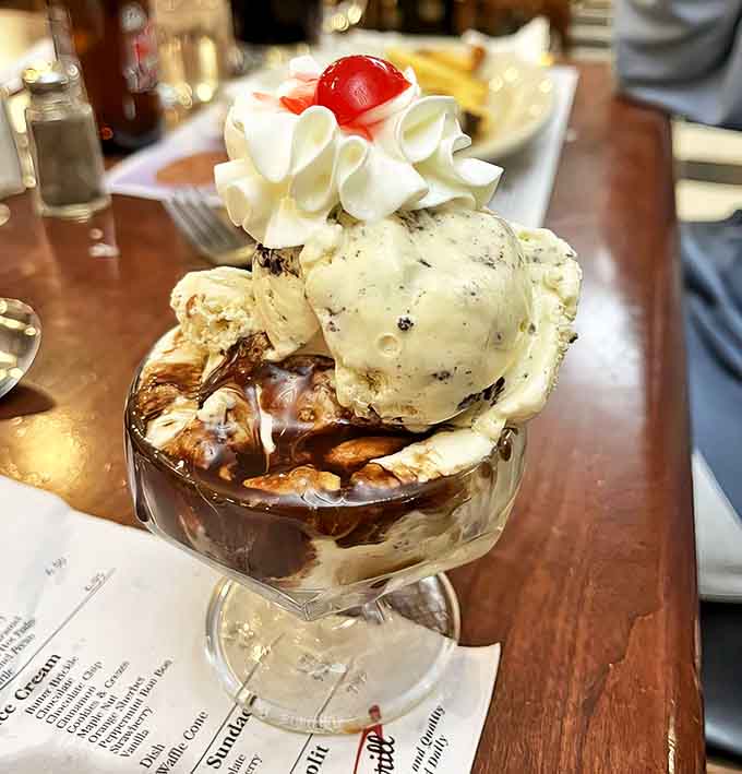 This hot fudge sundae isn't just dessert &ndash; it's an architectural marvel of ice cream, fudge, and whipped cream that defies both gravity and restraint.
