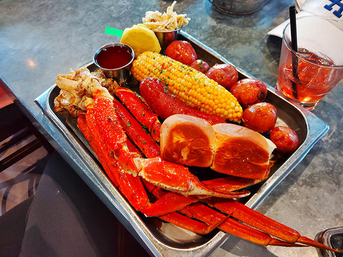 The seafood boil arrives like Neptune's treasure chest: bright red crab legs, corn, potatoes, and sausage ready for your most primal dining pleasure.