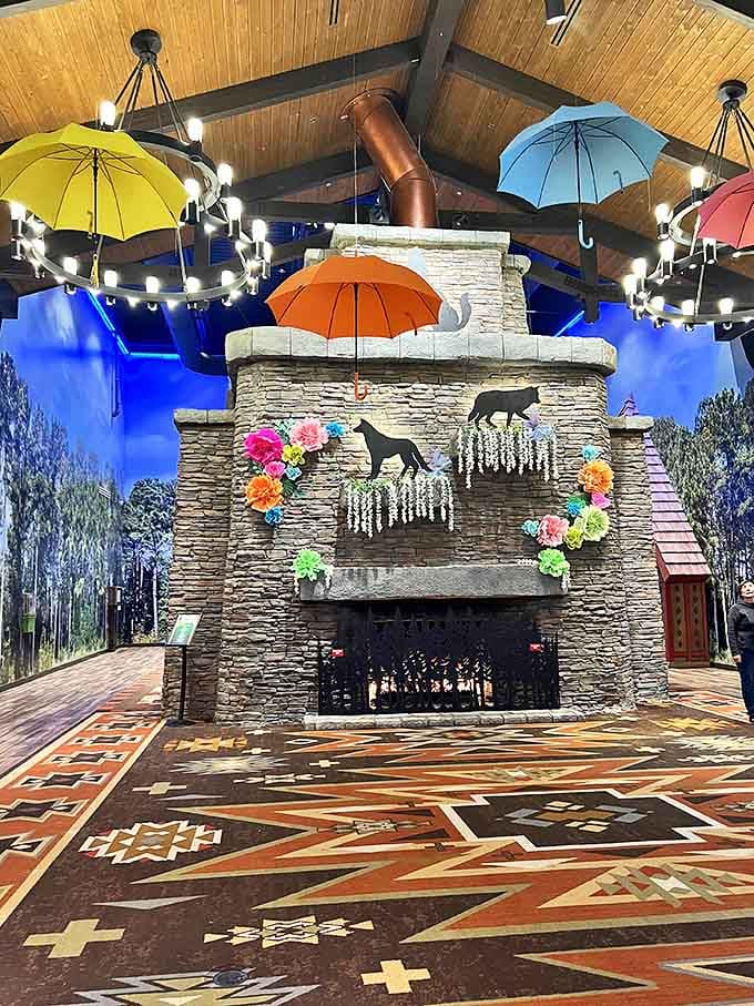 The grand lobby's stone fireplace creates a cozy gathering spot beneath colorful umbrellas, where storytime magic happens as evening falls.