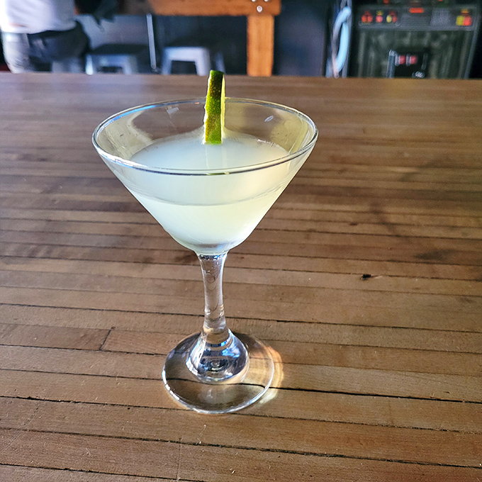 A classic martini stands elegantly against the wooden bar top, proving some things never go out of style.