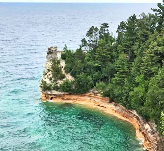 Miner's Castle stands like nature's own sculpture, where Lake Superior's turquoise waters meet multicolored cliffs in a geological masterpiece.