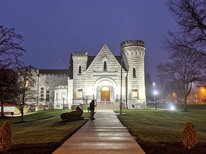 As darkness falls, the Brumback transforms into a glowing beacon of knowledge, its illuminated stone walls and windows creating a magical nighttime presence in Van Wert.
