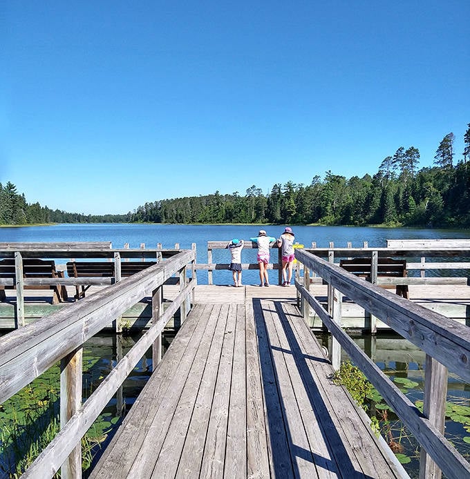 Three young explorers discovering that the real magic of Minnesota isn't on any screen – it's right here at the water's edge.