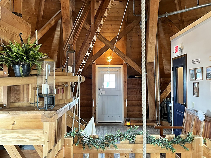 The windmill's warm wooden interior reveals the intricate system of ropes, beams, and gears that harness wind power.