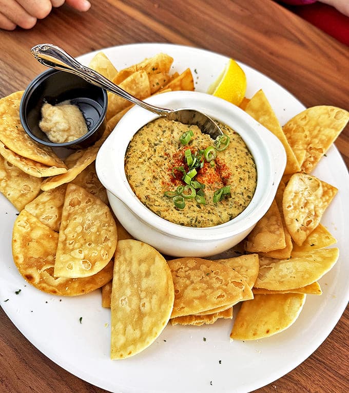 The crab dip arrives bubbling hot, ready for scooping with crisp tortilla chips &ndash; a perfect start to your island feast.