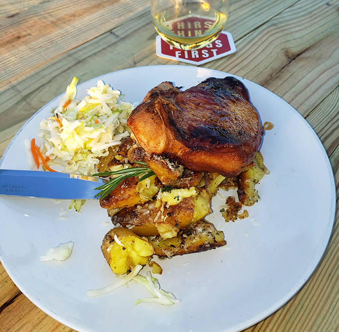 This isn't just any pork chop&mdash;it's a thick-cut masterpiece resting on smashed potatoes with a side of slaw. Meat sweats never felt so right.