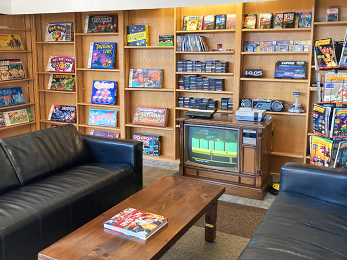 This cozy retro lounge area feels like the coolest kid's basement from 1988, complete with wood paneling and cartridge-filled shelves.