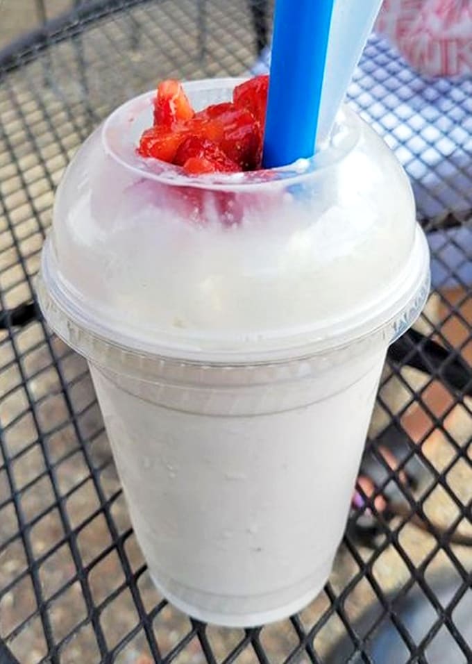 A frosty strawberry shake crowned with fresh berries – proof that drinking your dessert is sometimes the wisest life choice.
