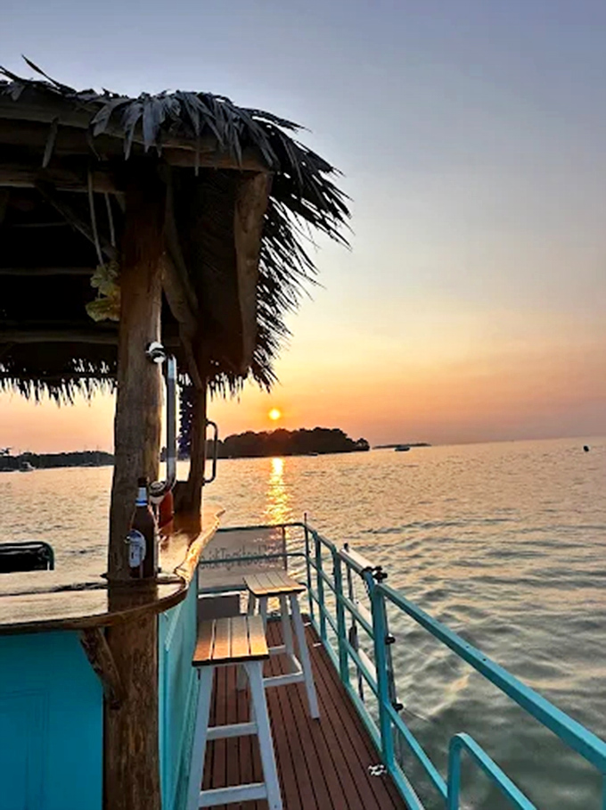 Silhouetted against a fiery Lake Erie sunset, the floating tiki creates postcard-perfect moments that no landlocked bar could match.