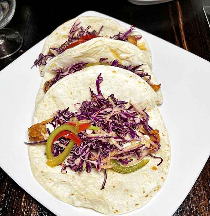 Tacos that balance freshness and indulgence &ndash; crisp purple cabbage and bright peppers provide the perfect counterpoint to savory fillings.