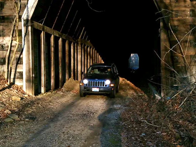 The Car Passer: A modern vehicle navigates this relic of transportation history, creating a striking contrast of past and present technologies.