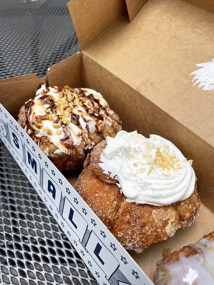 Turtle Cheesecake and Coconut Cream doughnuts nestled in their box &ndash; dessert masquerading as breakfast and doing a very convincing job.