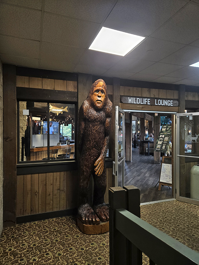 The Wildlife Lounge's wooden Sasquatch stands guard, silently judging your drink choices while reminding you that the wilderness holds many secrets.