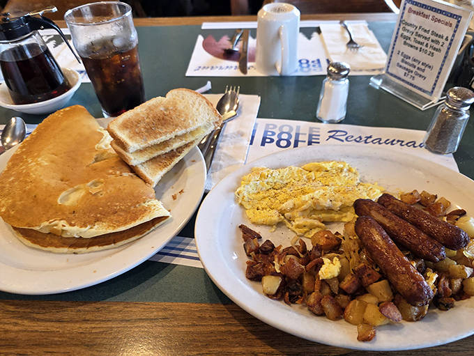 Start your day right with a hearty breakfast of fluffy pancakes, eggs, and sausage in a warm, welcoming atmosphere.