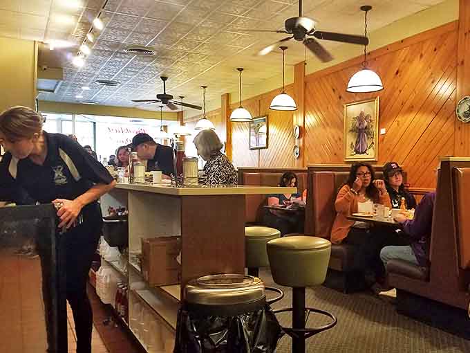 The counter seating offers front-row tickets to the breakfast show, where coffee flows freely and conversations bloom between strangers.