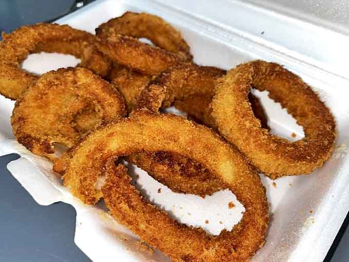 Onion rings with architectural integrity &ndash; substantial sweet onion centers encased in crispy, golden batter that shatters just right.