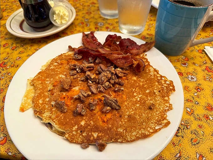 Pancakes that redefine breakfast indulgence &ndash; fluffy golden discs topped with candied pecans and bacon that blur the line between meal and dessert.