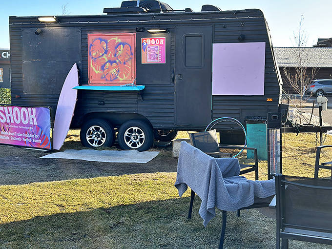 The outdoor seating area at Shook invites you to linger, with surfboards and cozy chairs creating a laid-back North Shore vibe.