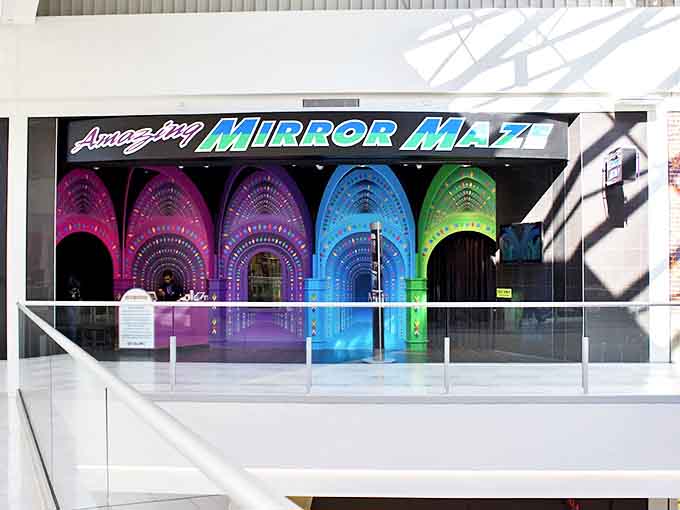 A moment of decision at the entrance: which colorful archway leads to the exit, and which leads deeper into the reflective puzzle?