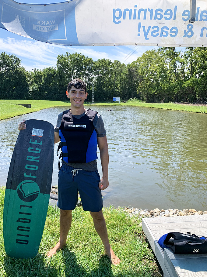 A proud boarder shows off their equipment, blissfully unaware of how many times they'll be reunited with the lake today.