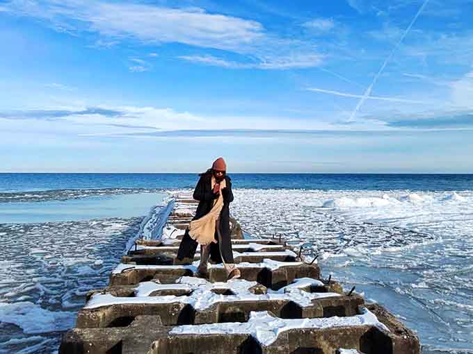 Winter transforms the shoreline into a magical ice kingdom where brave souls venture onto frozen formations.