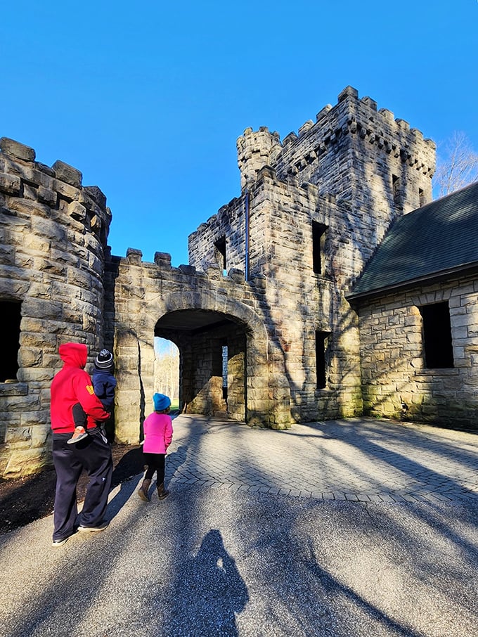 Visitors explore the castle's stone archway, perhaps half-expecting to find a moat, drawbridge, or at minimum, a knight selling souvenir t-shirts.