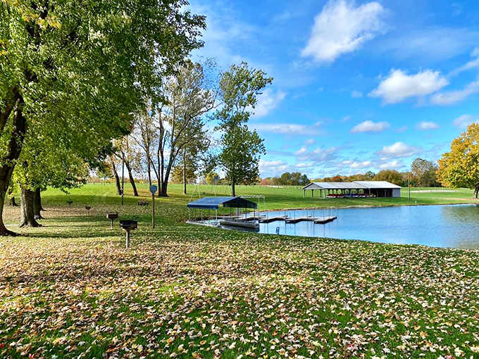 Autumn transforms the park into a canvas of golden hues, reflecting perfectly on the still water of the off-season lake.