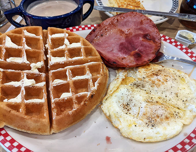 Morning glory on a plate – a Belgian waffle with perfect grid marks flanked by eggs and ham that would make Dr. Seuss proud.