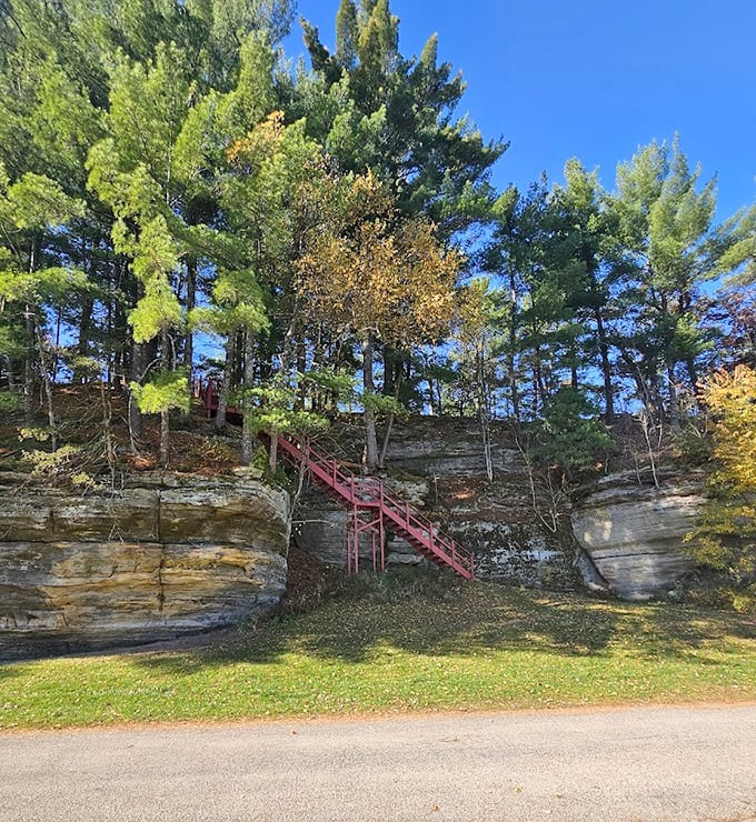 Red stairs climb the rock face like a geometric contrast to nature's flowing lines&mdash;human ingenuity meeting ancient geology.