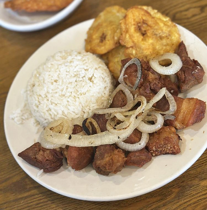Crispy cubes of pork heaven served with rice and sweet plantains &ndash; the kind of dish that inspires poetry.