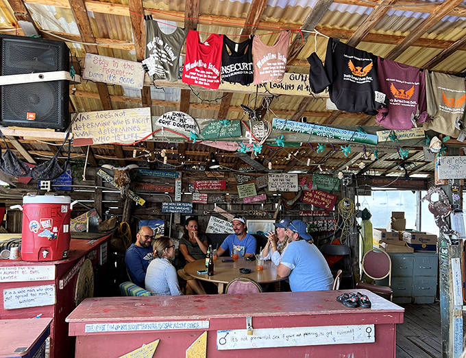 Beneath a ceiling festooned with t-shirts and wisdom-filled signs, patrons gather around tables that have heard thousands of island stories.