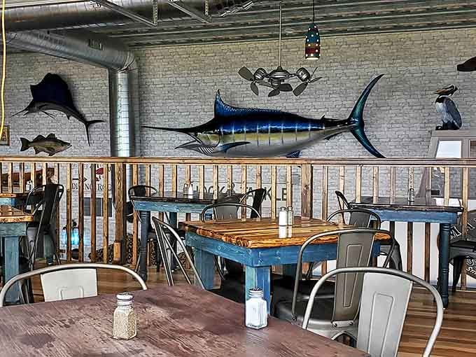 Upstairs dining offers a maritime museum vibe, where mounted fish seem to swim across whitewashed walls above rustic blue tables.
